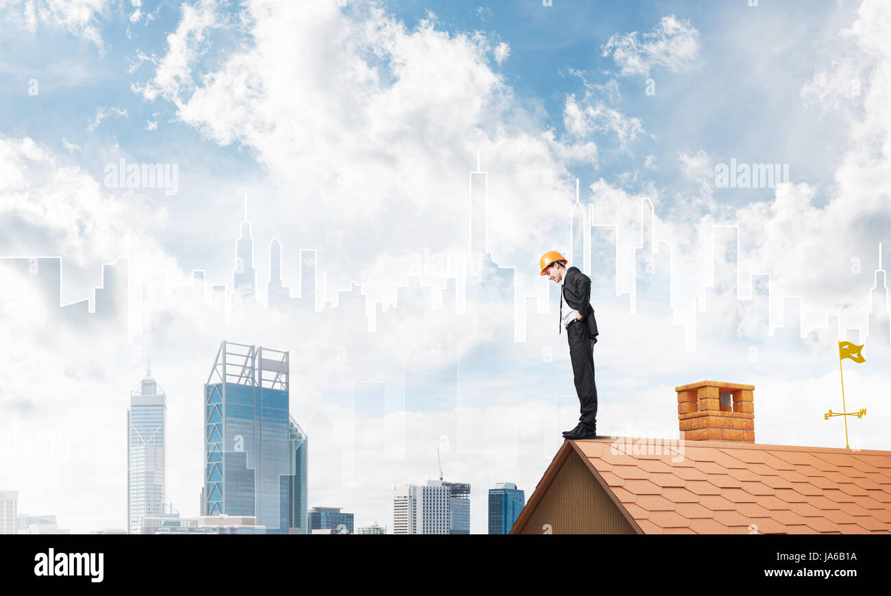 Engineer man standing on roof and looking down. Mixed media Stock Photo ...