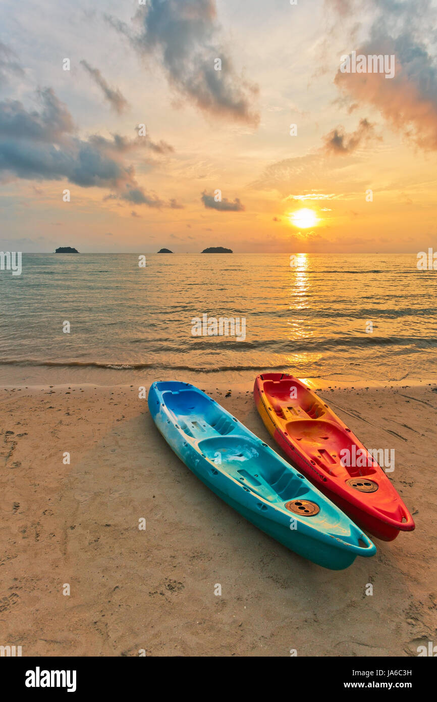 Kayaks on the beach during sunset Stock Photo - Alamy