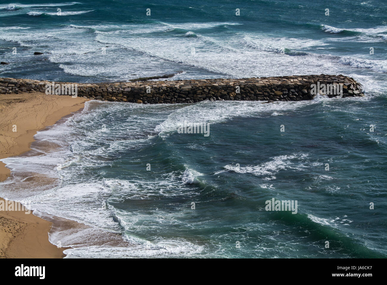 water breaking on sand, beach with rock structure Stock Photo - Alamy