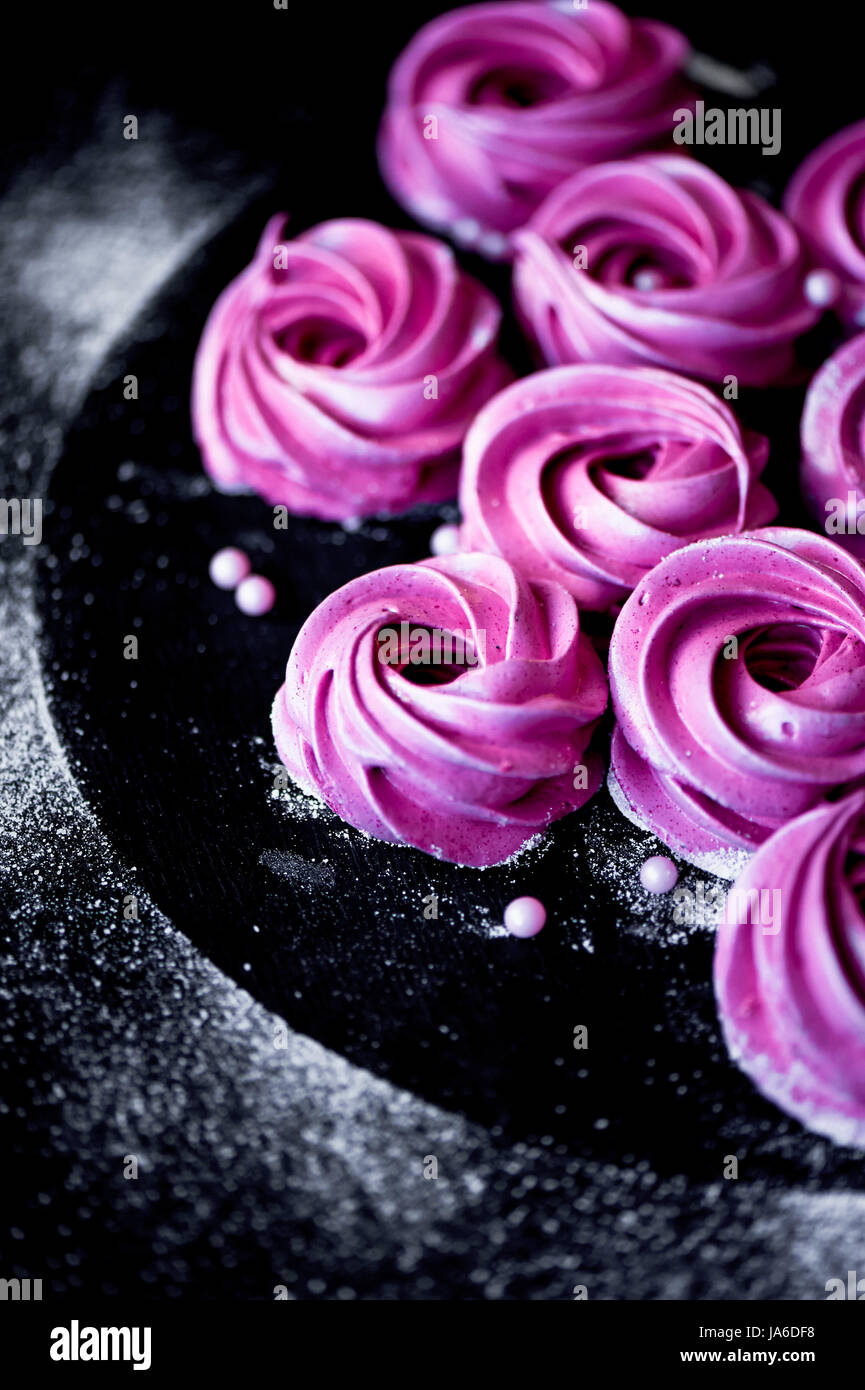 Many purple marshmallow on a dark surface. A contrasting picture. A ...