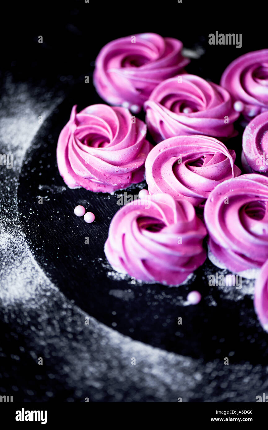 Many purple marshmallow on a dark surface. A contrasting picture. A ...