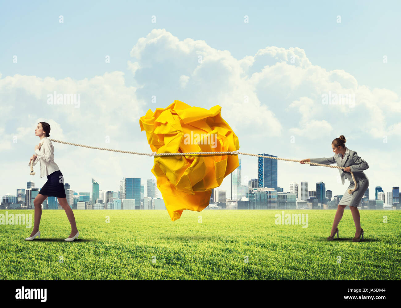 Two women pulling with effort big crumpled ball of paper as creativity ...