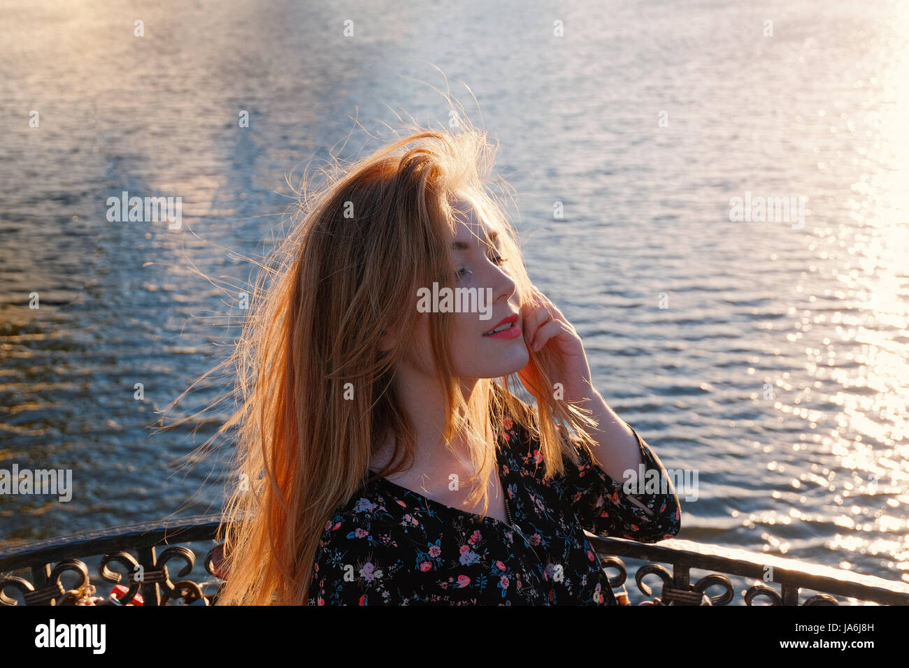 Happy calm woman relaxing in sun light near water Stock Photo - Alamy