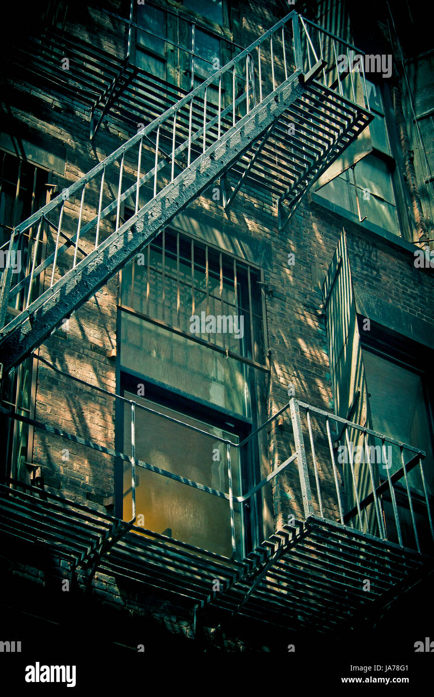 Iron fire escape stairs and balconies on the facade of a building in ...
