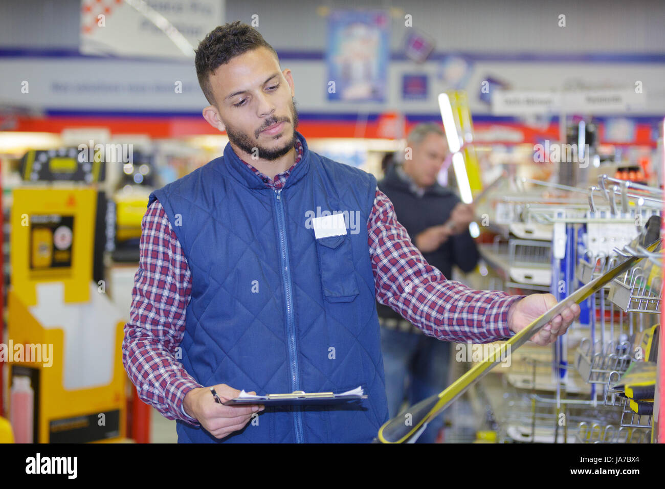 man checking his clipboard before purchasing in a hardware-store Stock ...
