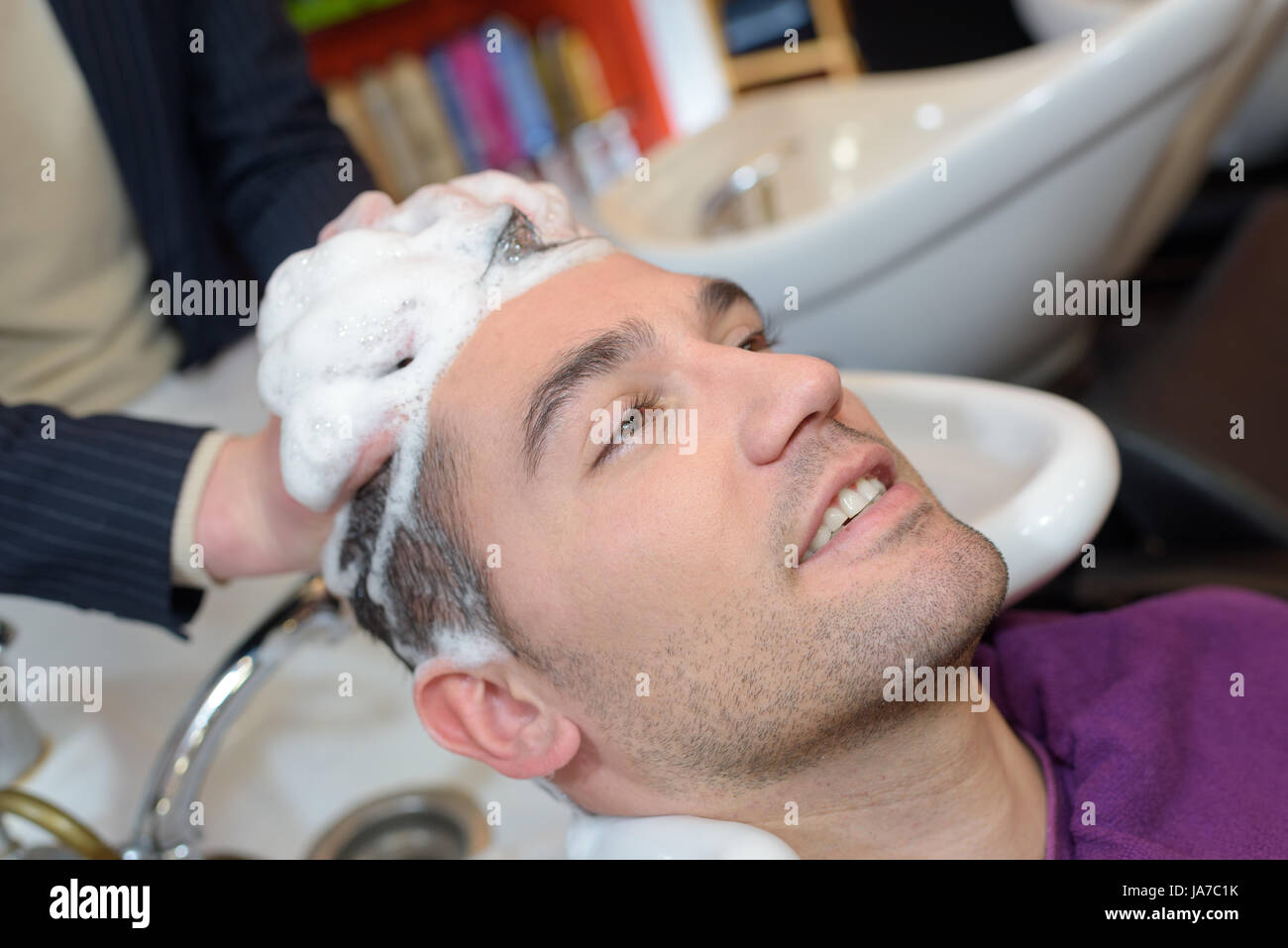 man washing head to client in barbershop Stock Photo - Alamy