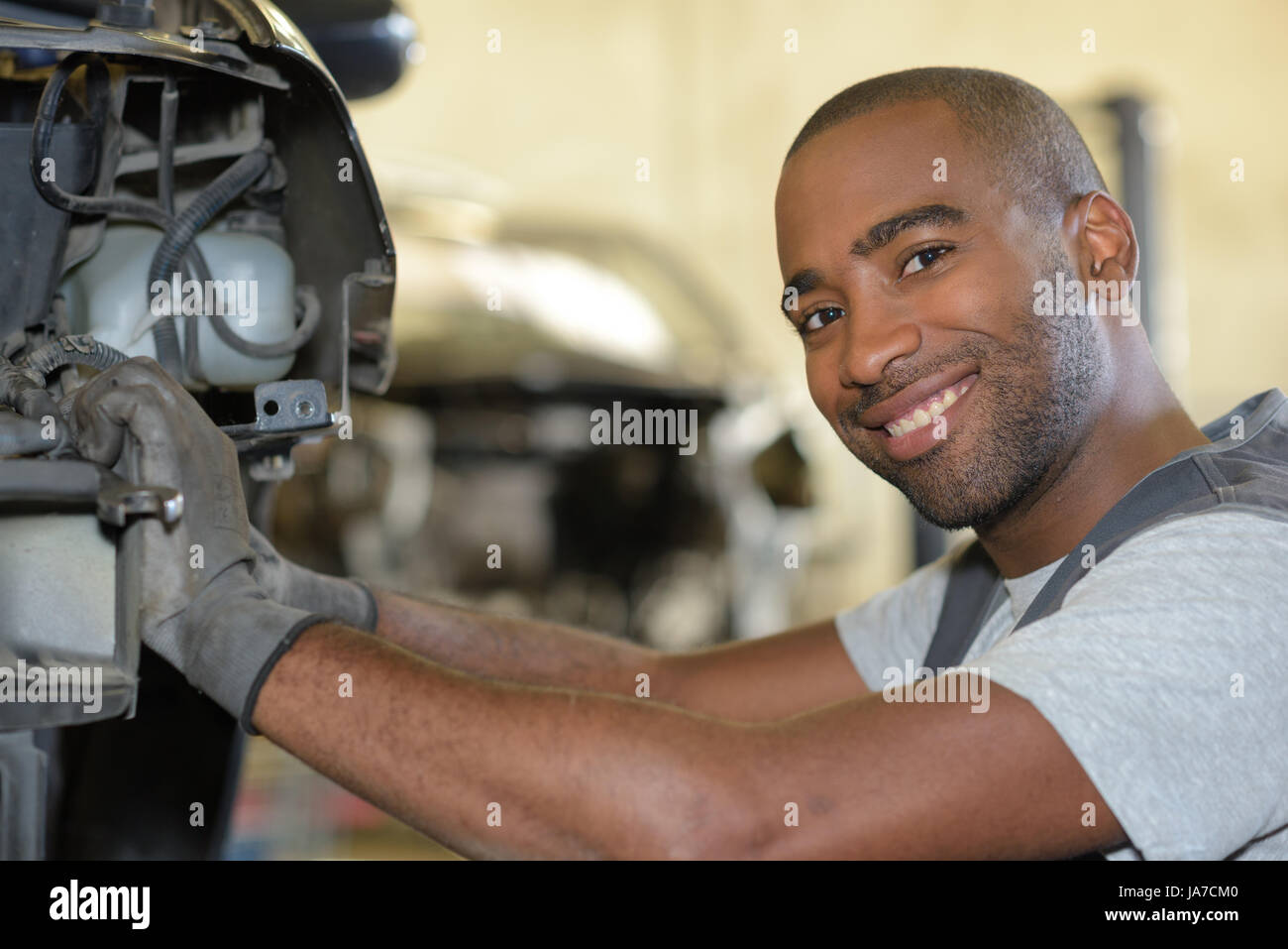 smiling mechanic fixing a car engine in his garage Stock Photo - Alamy