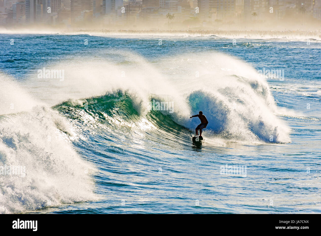 Surfer and wave with water spray at Ipanema beach in Rio de Janeiro ...