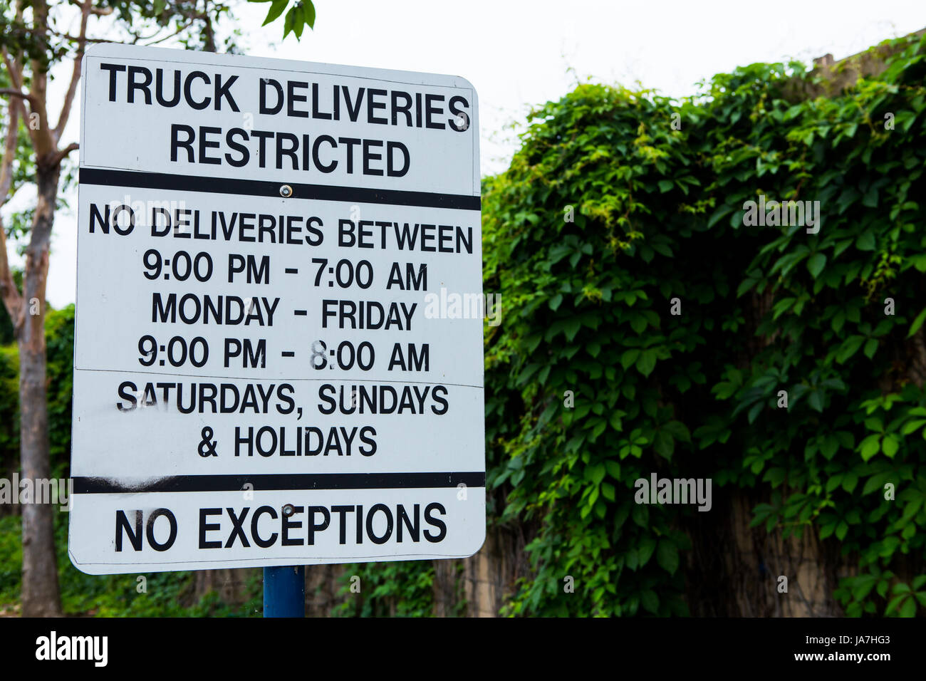 Restricted truck delivery times sign between the back of a strip mall ...