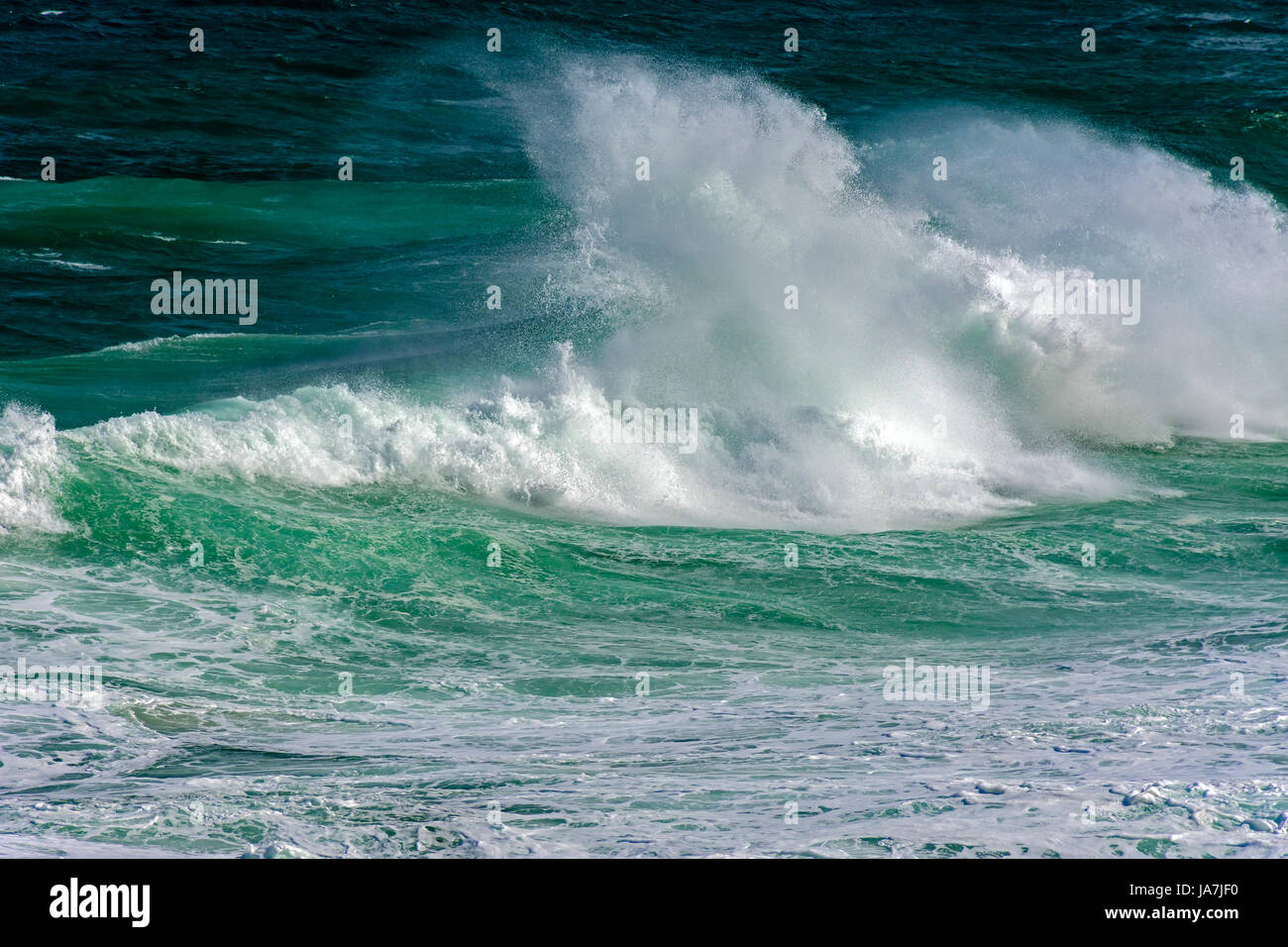 Wave crashing against rocks during storm Stock Photo - Alamy