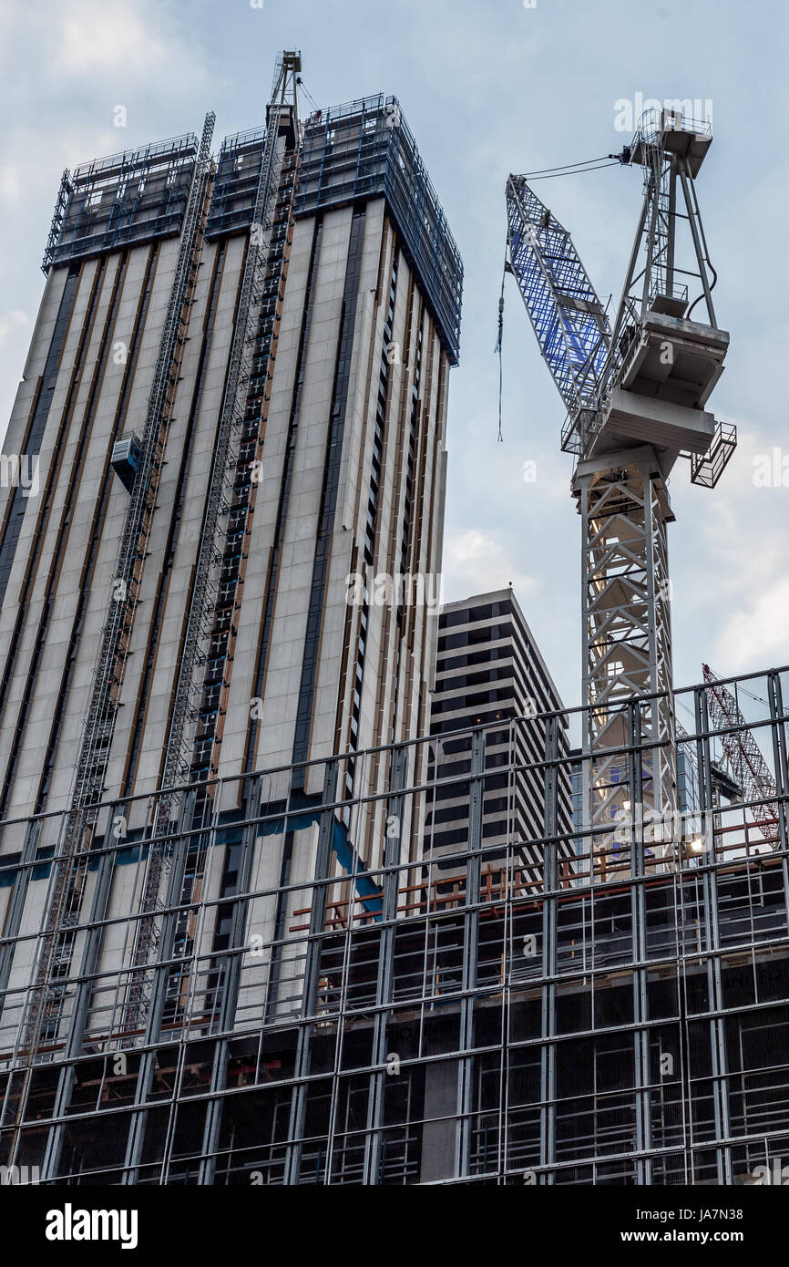 Cranes constructing tall building Stock Photo - Alamy