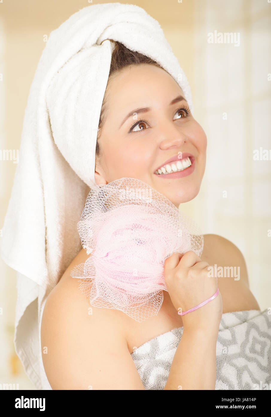 Beautiful fresh young girl wearing towel holding pink loofah body ...