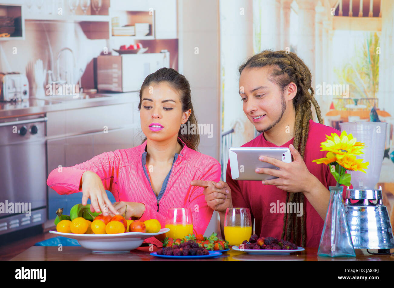 Hispanic young healthy couple enjoying breakfast together, sharing ...