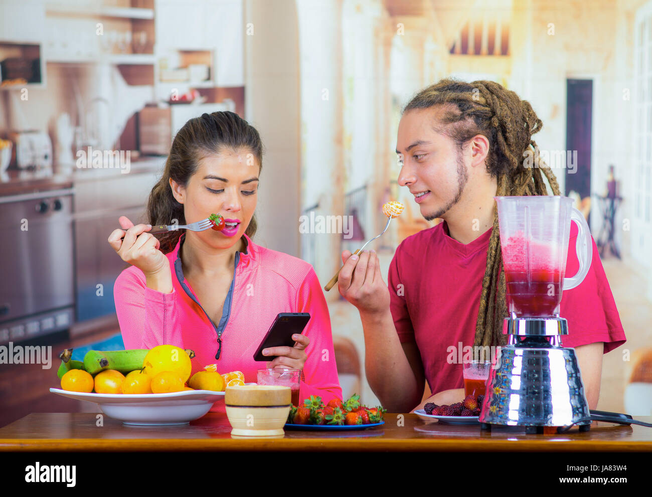 Hispanic young healthy couple enjoying breakfast together, sharing ...