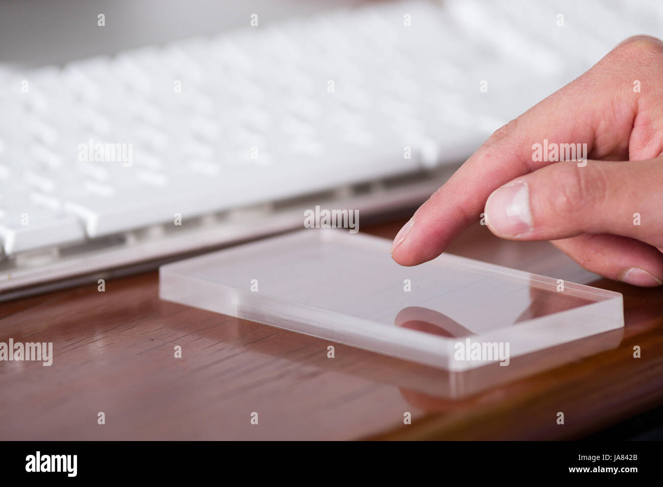 Man using a futuristic transparent smart phone on a wooden table Stock ...