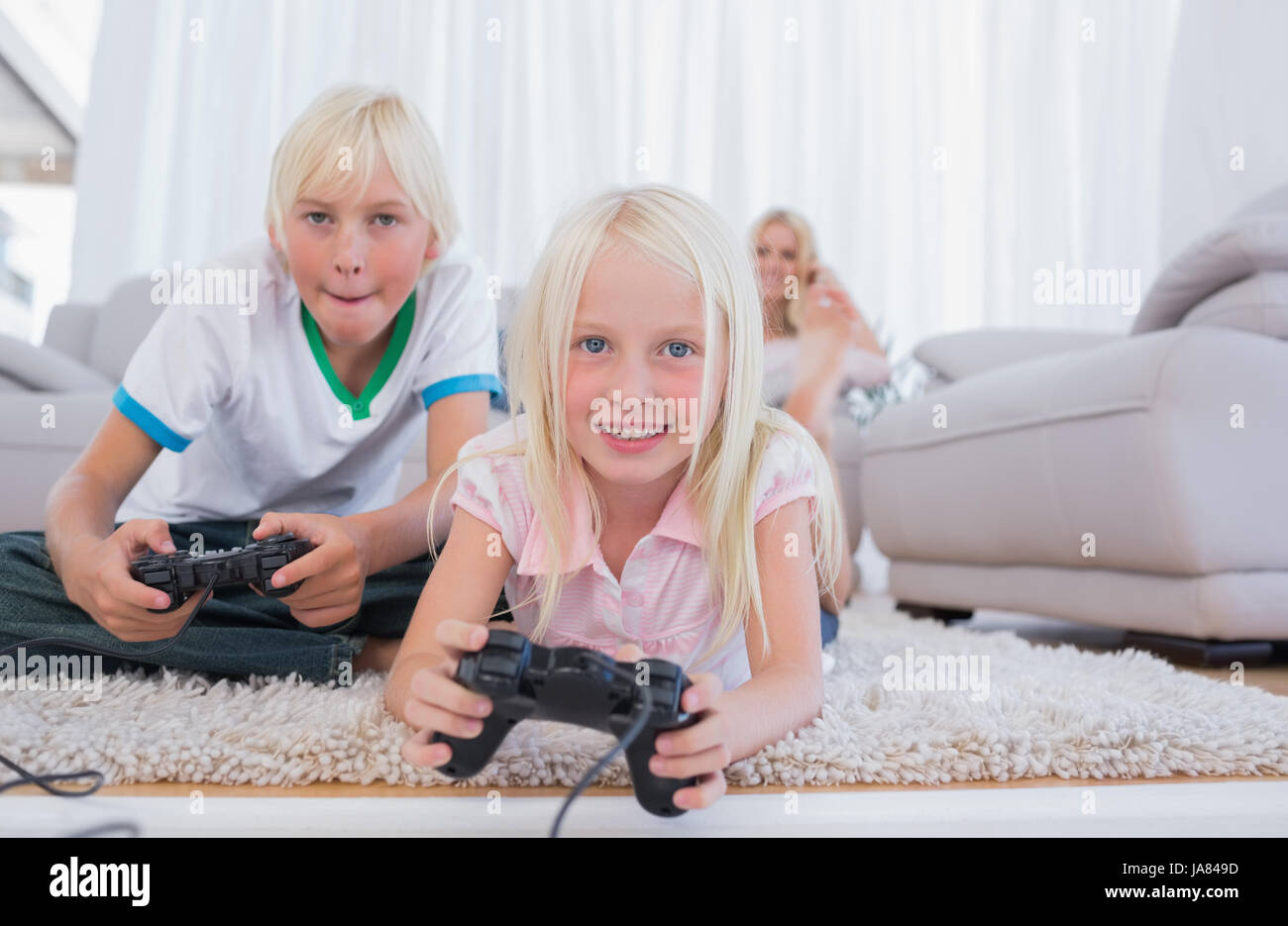 Siblings playing video games in the living room Stock Photo - Alamy