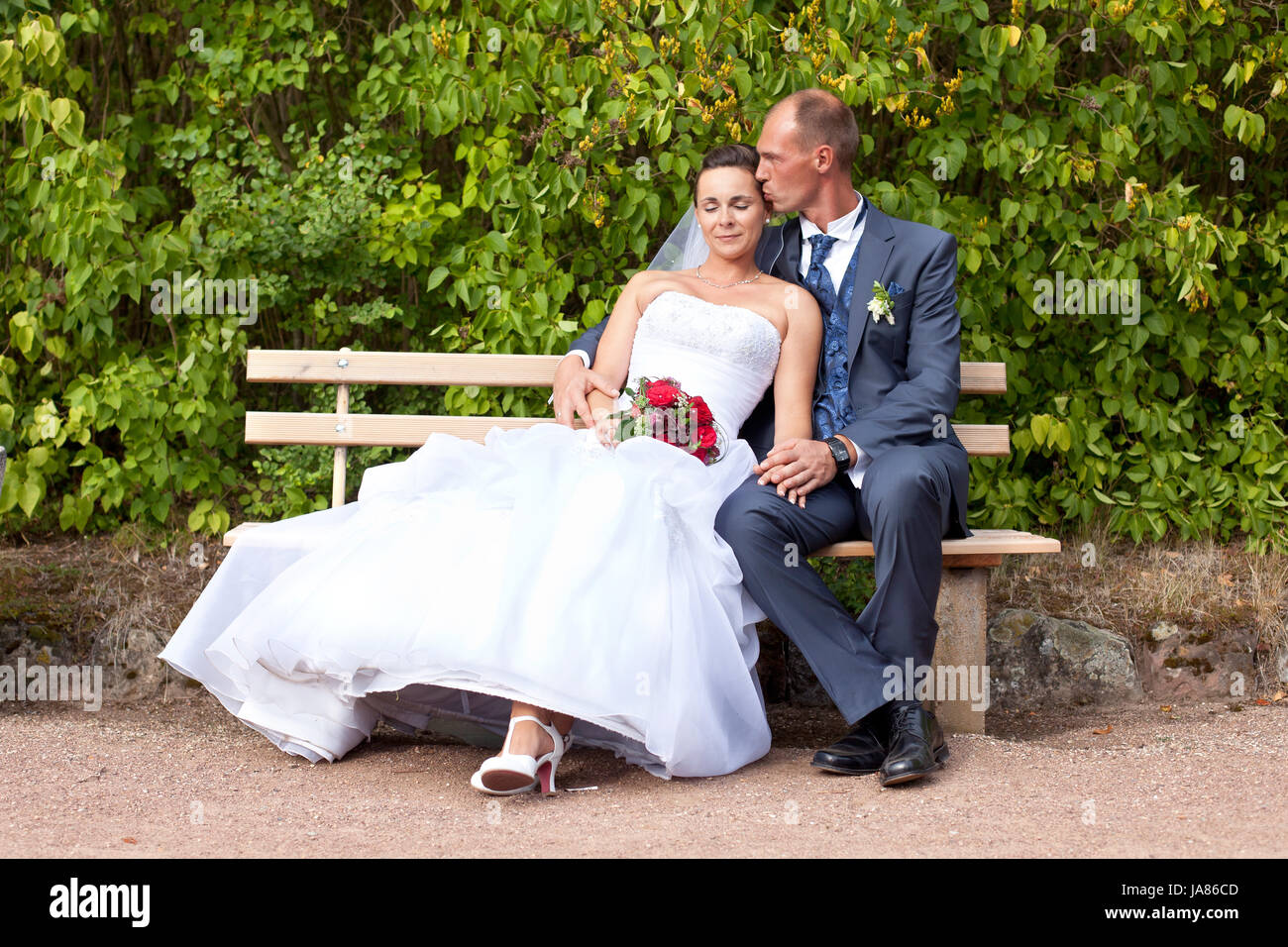 bridal couple sitting on a bench Stock Photo - Alamy