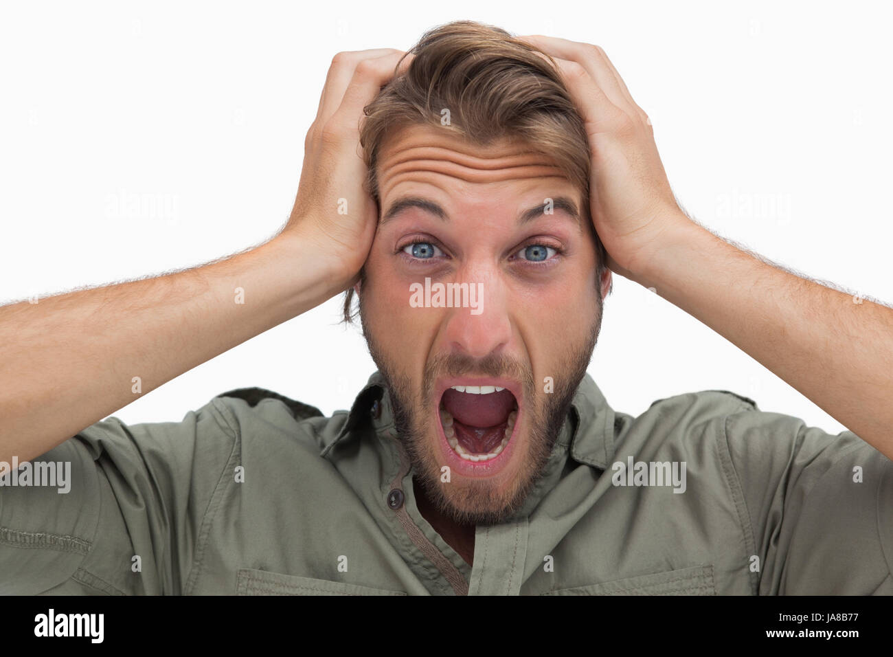 Angry man with hands on head on white background Stock Photo - Alamy