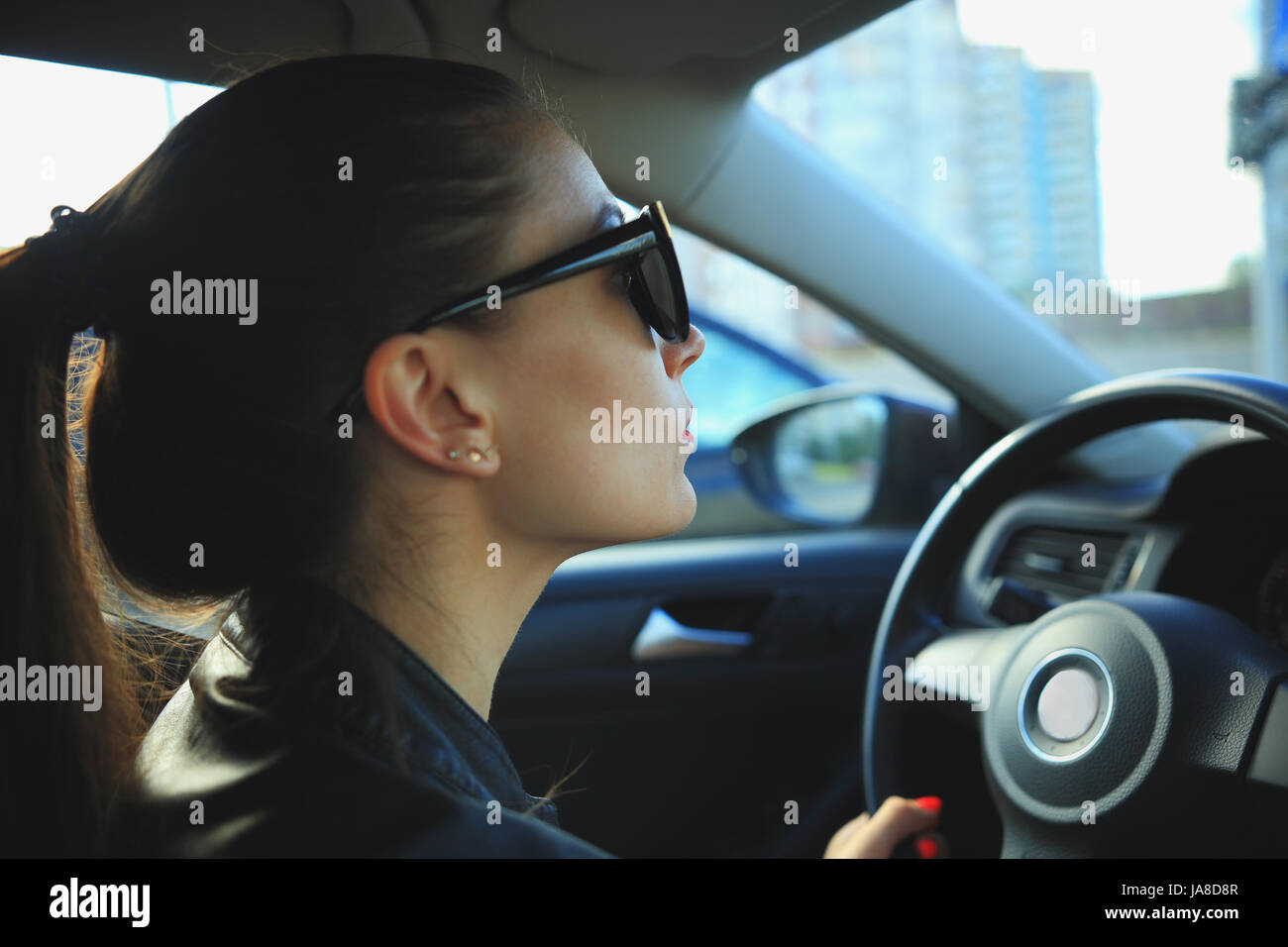 Woman driving car close-up. Portrait of woman in glasses in new car ...