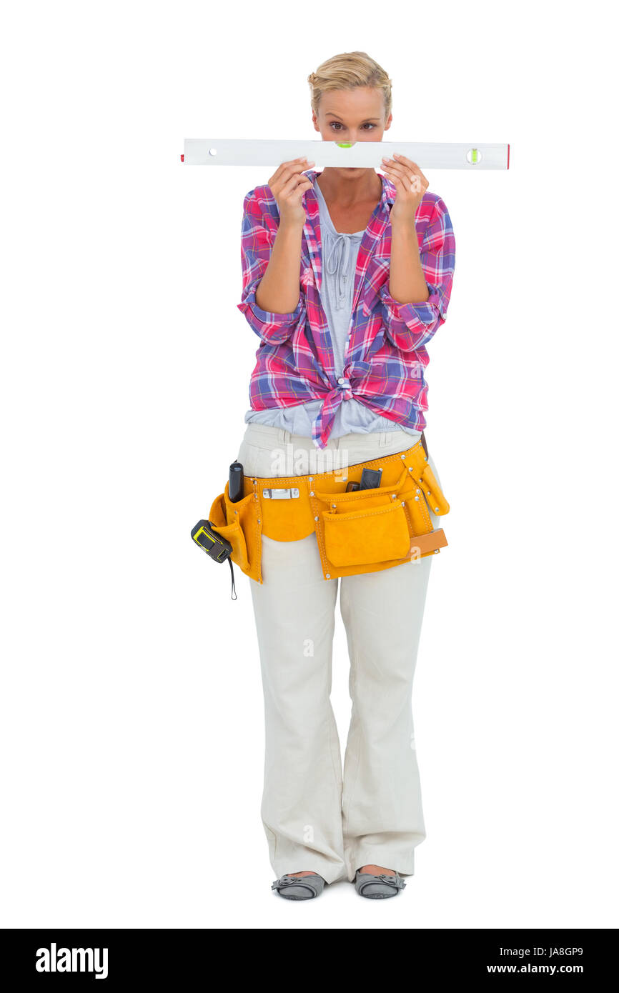 Blonde woman looking at spirit level on white background Stock Photo ...