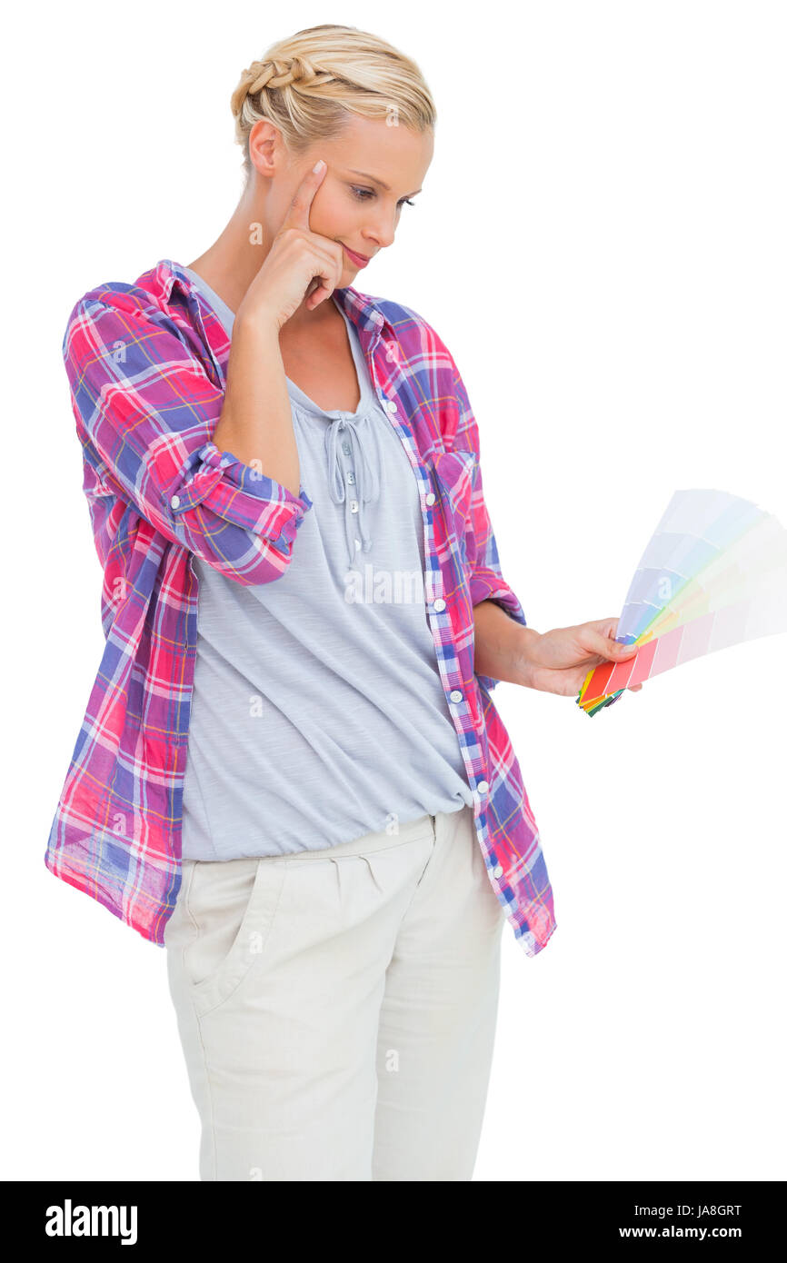Serious blonde looking at color charts on white background Stock Photo ...
