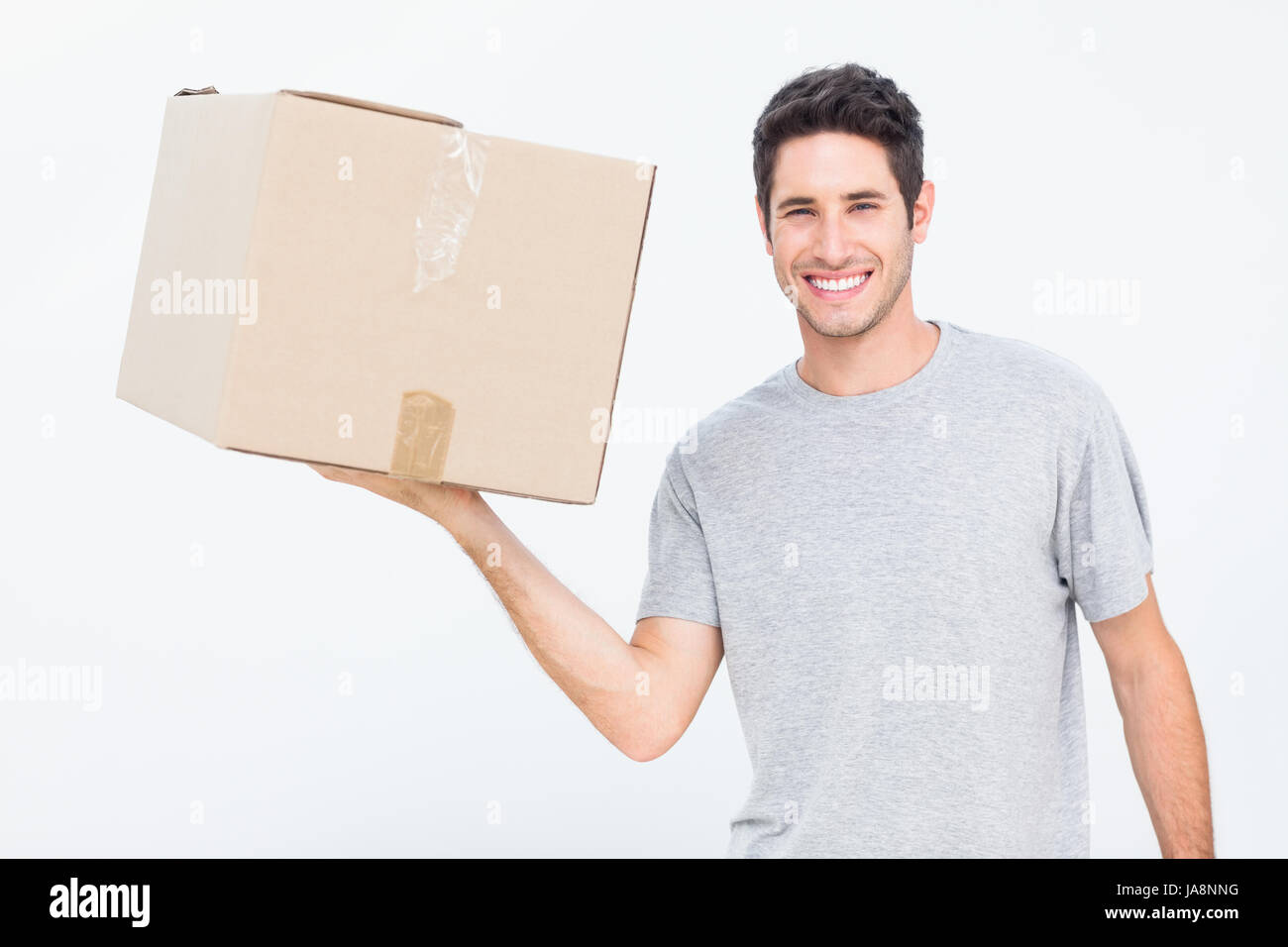 Cheerful man holding a box with one hand Stock Photo - Alamy
