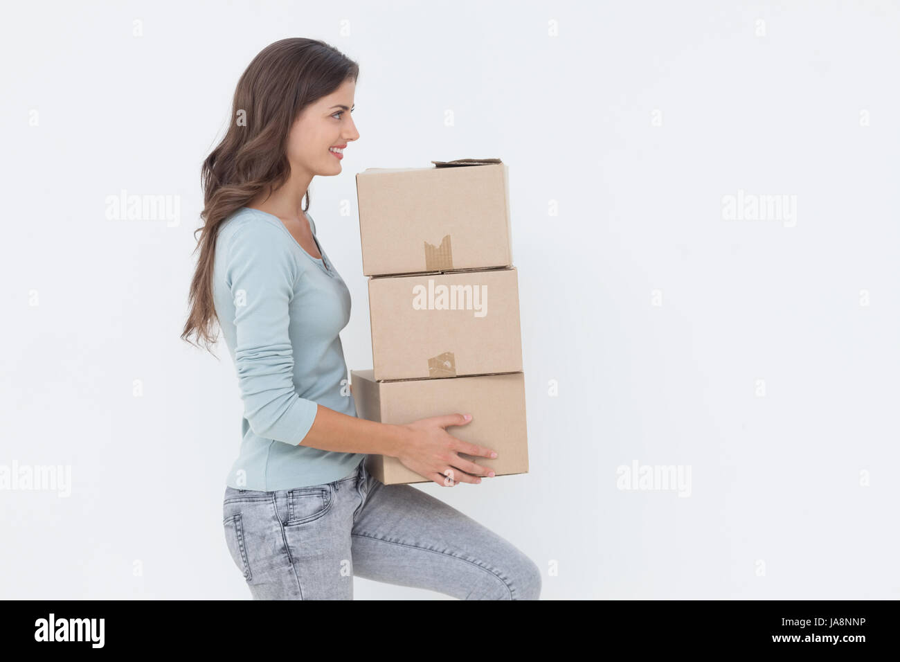 Attractive woman holding boxes because she is moving in a new house ...