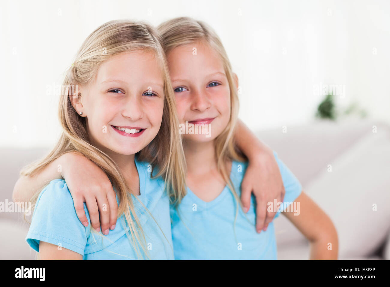 Happy twins embracing each other in the living room Stock Photo - Alamy
