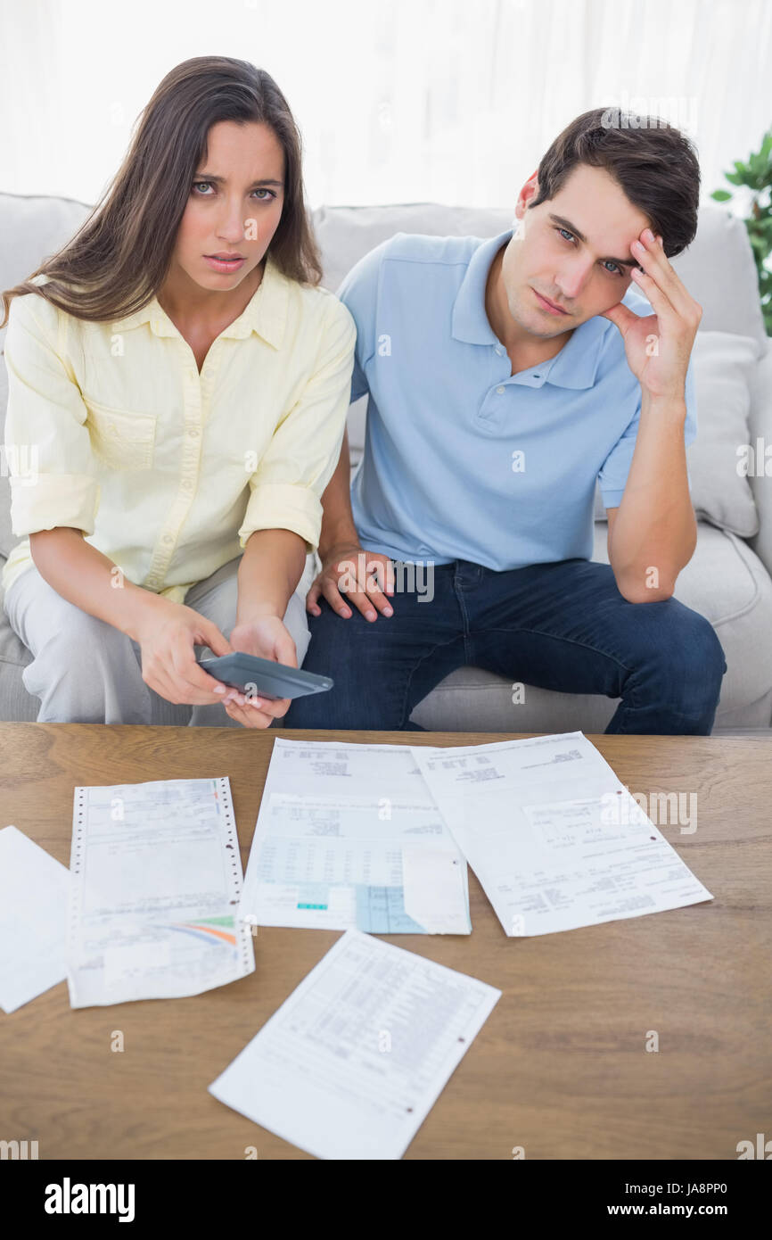 Concerned couple doing their accounts sat on a couch Stock Photo - Alamy