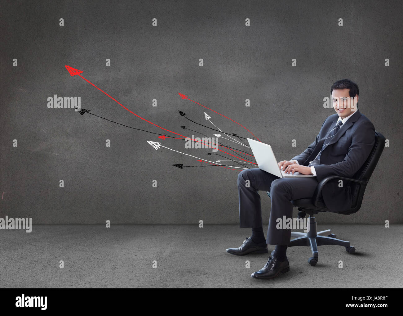 Businessman using his laptop arrows coming from it sitting in swivel ...