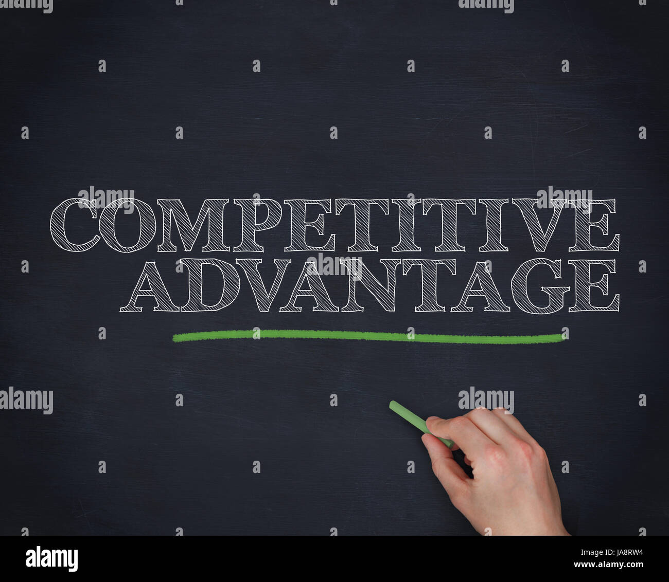 Hand underlining the word competitive advantage in green blackboard ...