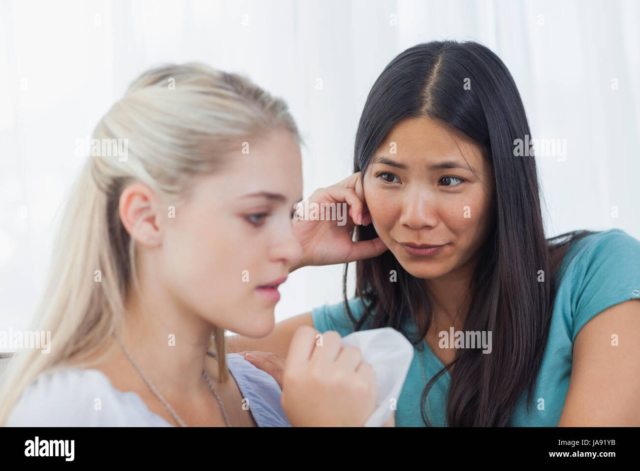Blonde crying and talking as her friend is listening at home on the ...