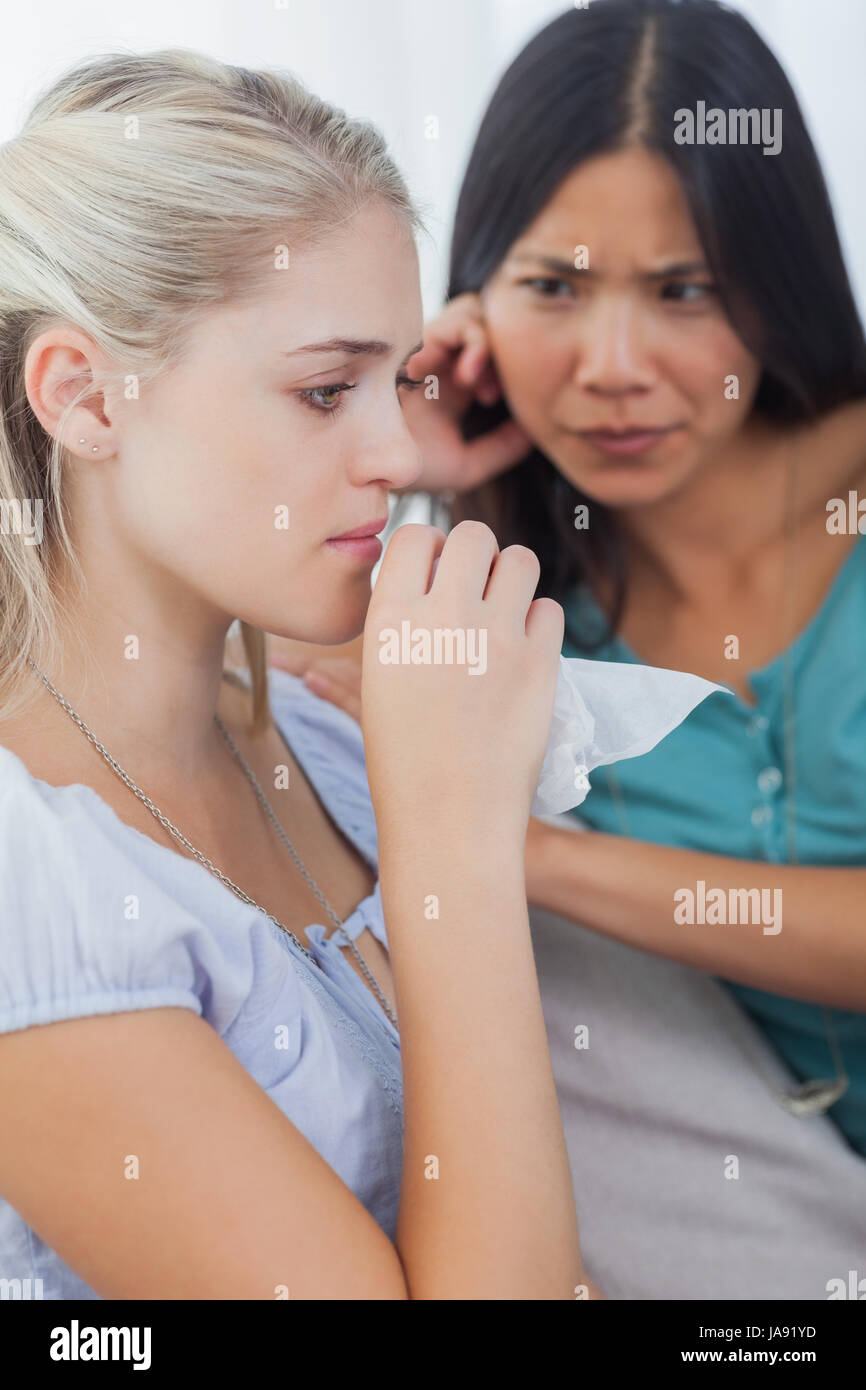 Blonde crying and talking as her concerned friend is listening at home ...