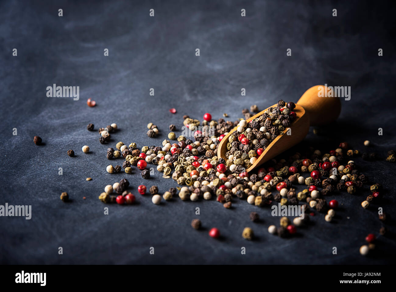 Multi-colored peppercorns in a wooden bucket on a dark background Stock ...