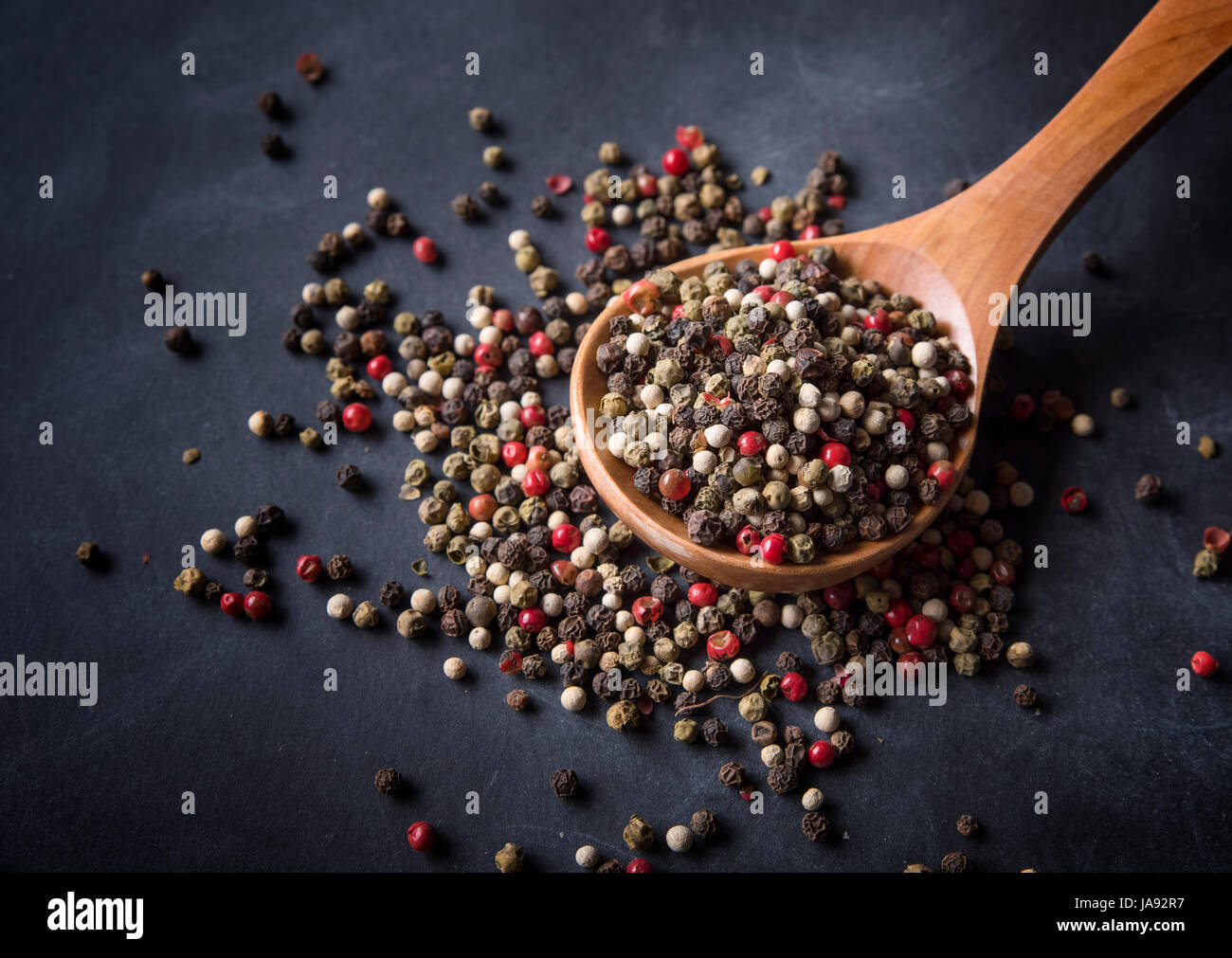 Multi-colored peppercorns in a wooden bucket on a dark background Stock ...