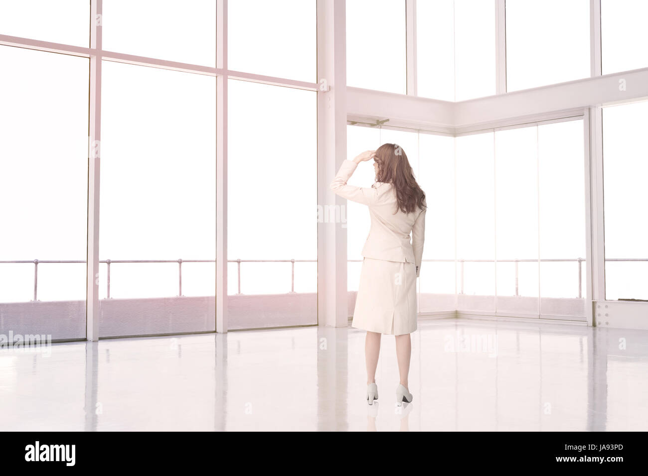 Businesswoman standing in a bright empty room Stock Photo - Alamy