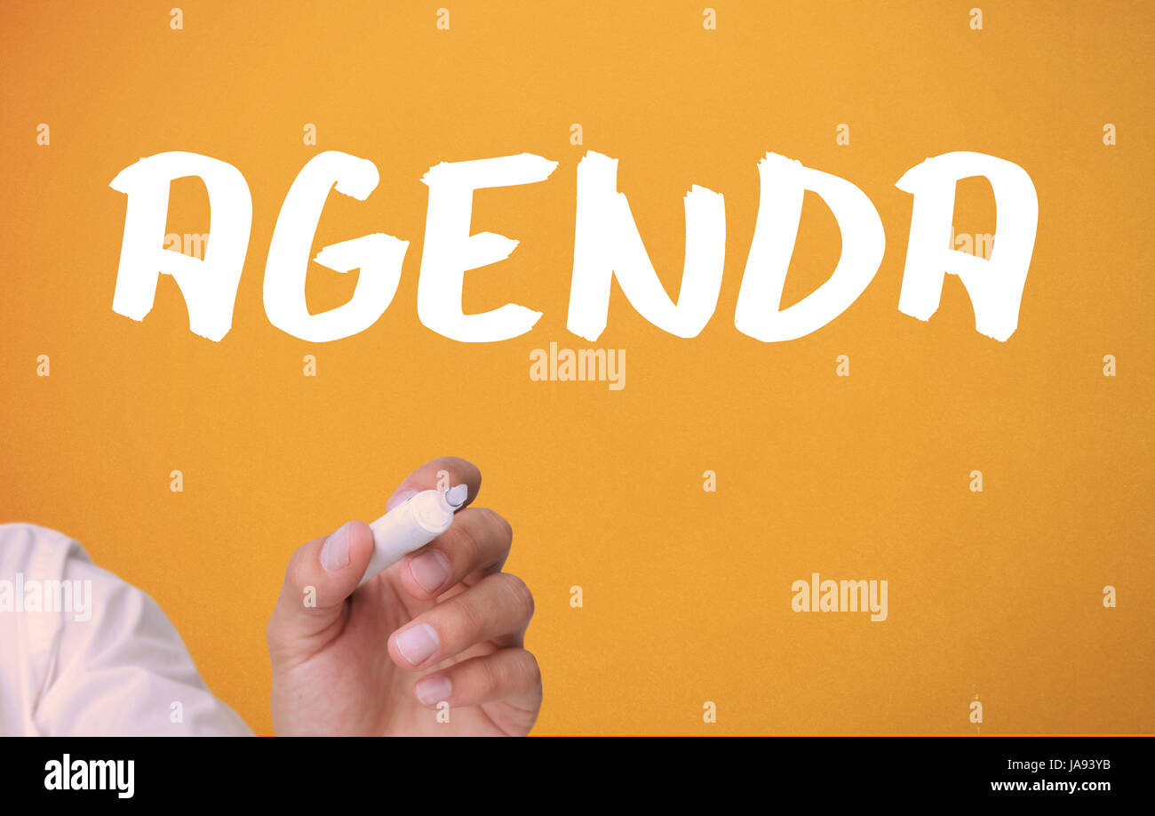 Businessman writing agenda on orange background Stock Photo - Alamy