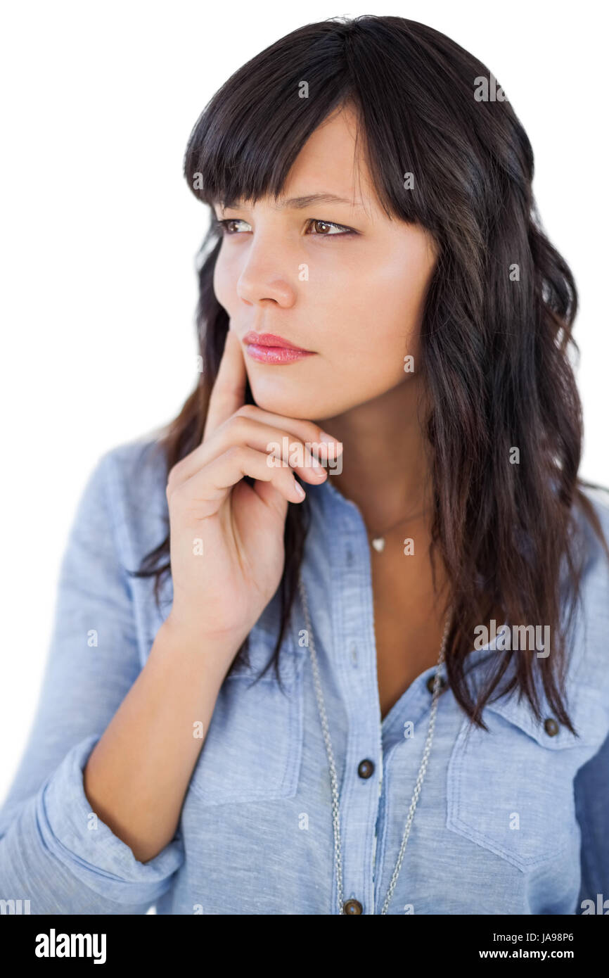 Thinking brunette with finger on her face looking away on white ...