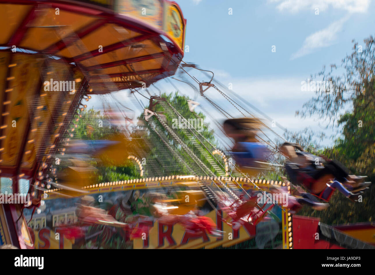Chain swing carousel ride at a carnival with motion blur during sunset ...
