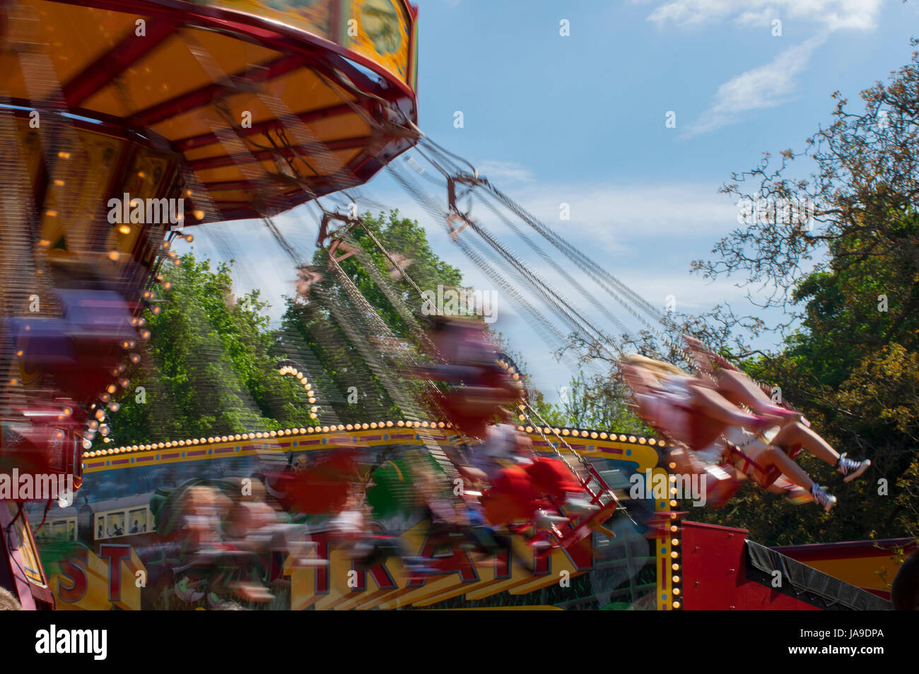 Chain swing carousel ride at a carnival with motion blur during sunset ...