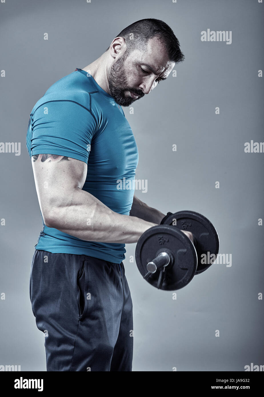 Fitness trainer doing biceps workout in the studio Stock Photo - Alamy