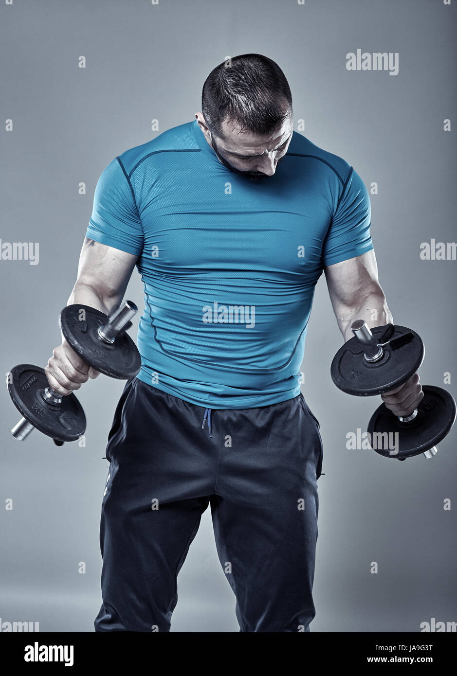 Fitness trainer doing biceps workout in the studio Stock Photo - Alamy