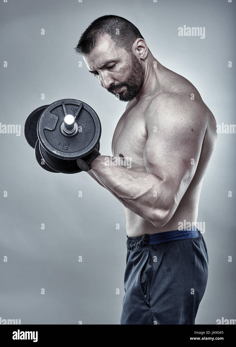 Fitness trainer doing biceps workout in the studio Stock Photo - Alamy