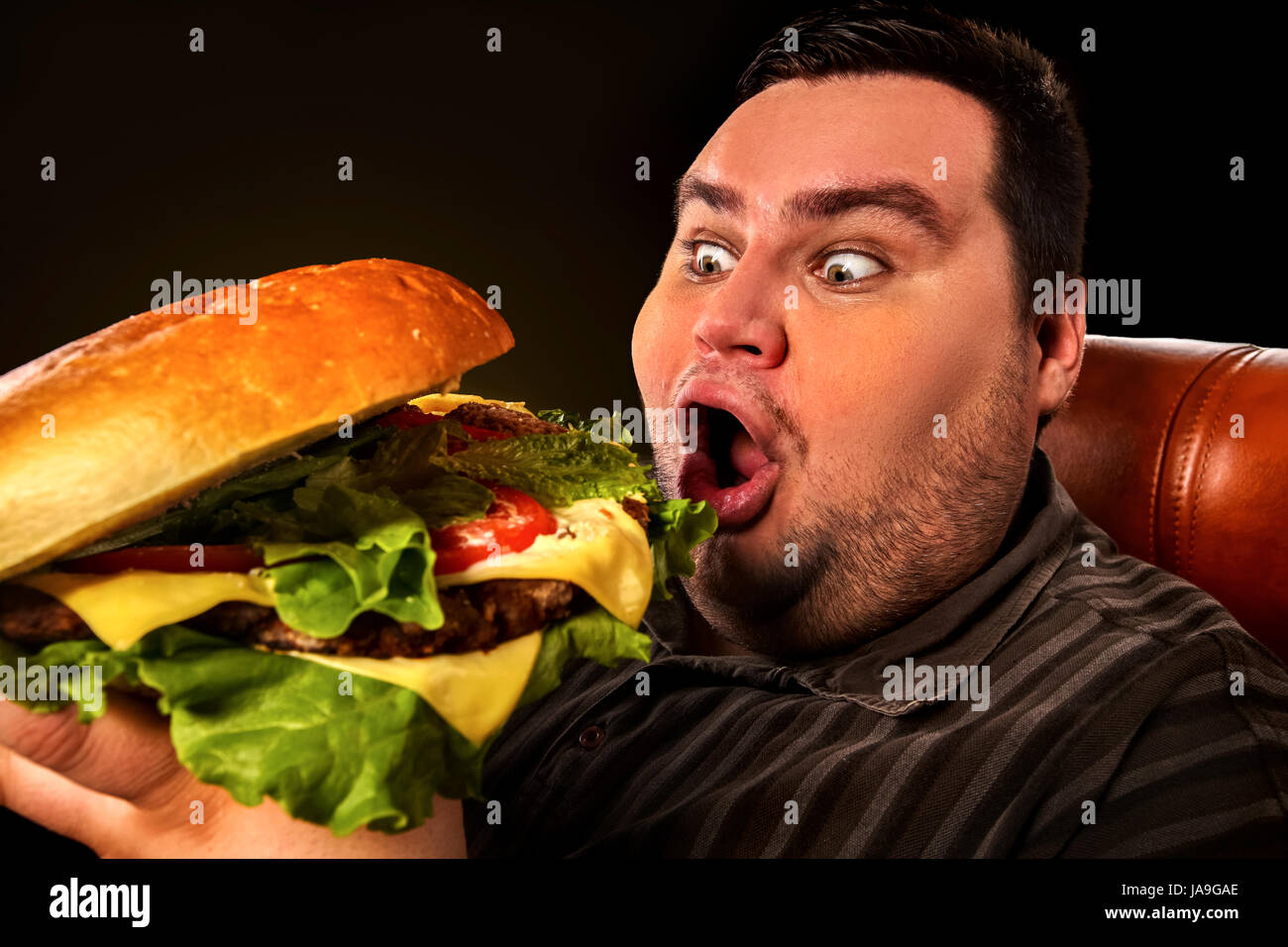 Fat man eating fast food hamberger. Breakfast for overweight person ...