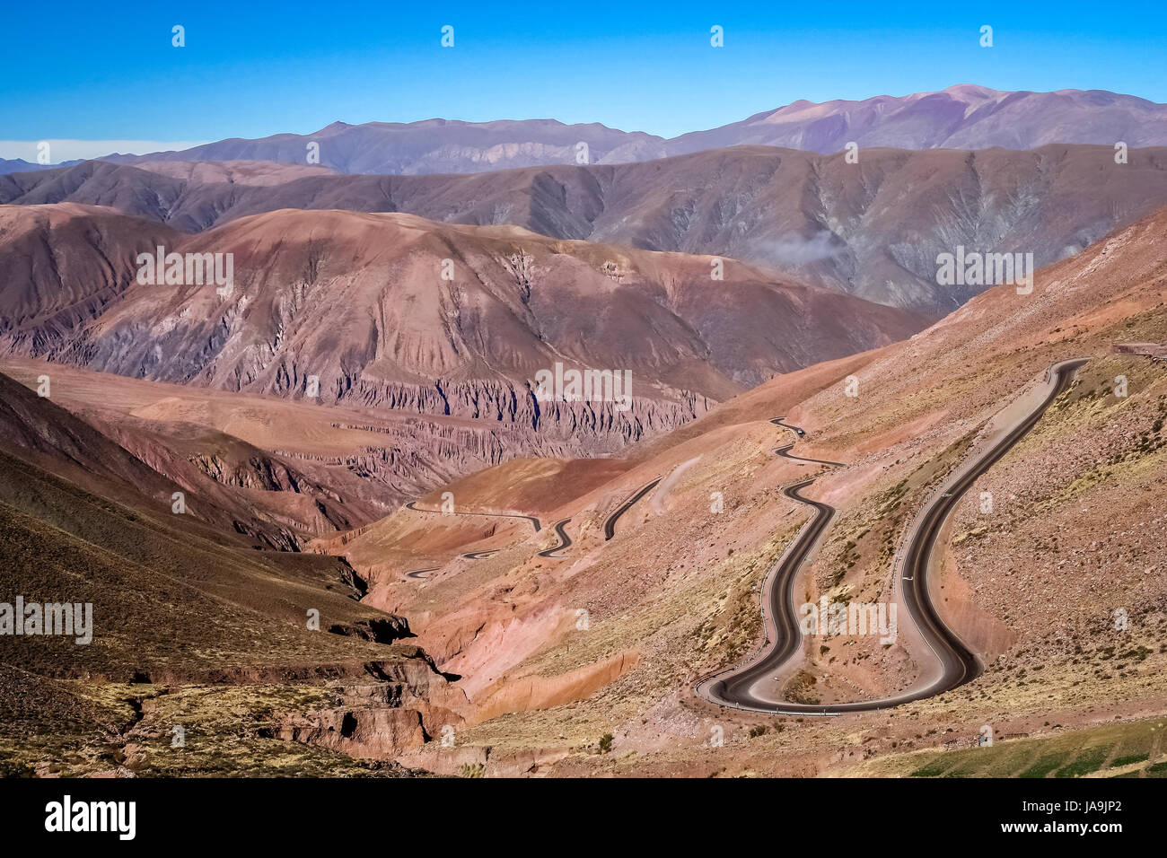 Twisting road from the high plateau to Quebrada de Humahuaca mountains ...