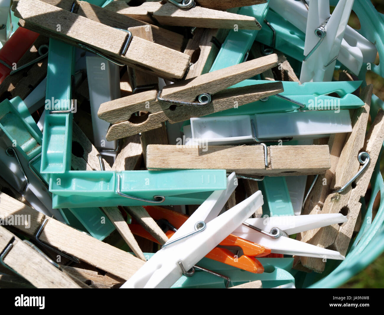 Plastic and wooden clothes pegs in basket Stock Photo - Alamy