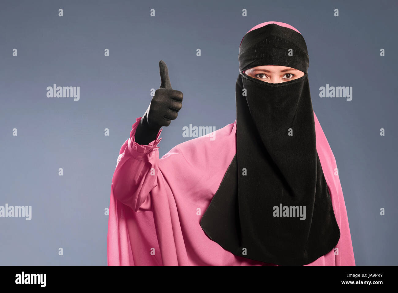 Portrait of asian muslim woman in hijab showing fine sign over dark ...