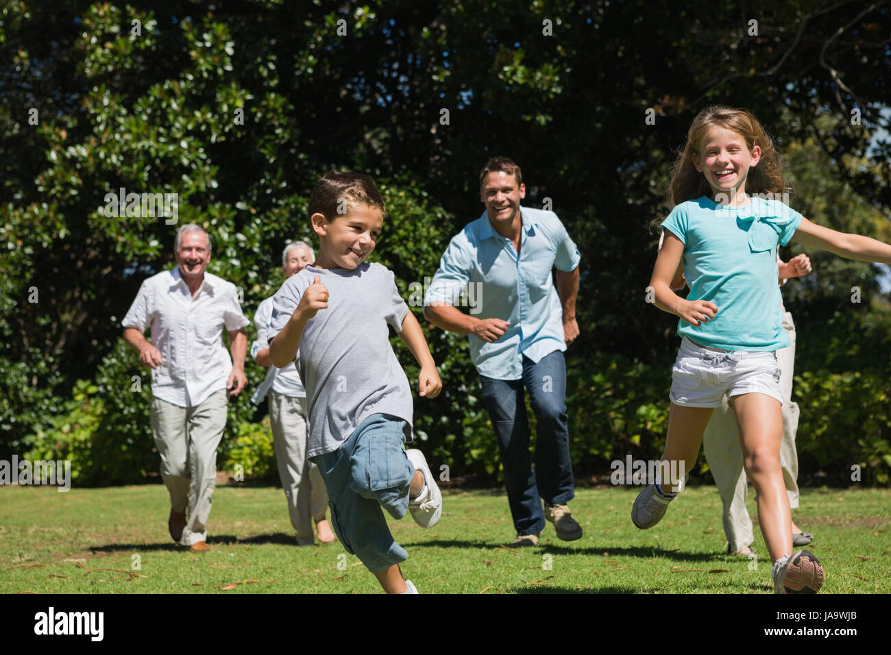 Happy multi generation family racing towards camera in a park Stock ...
