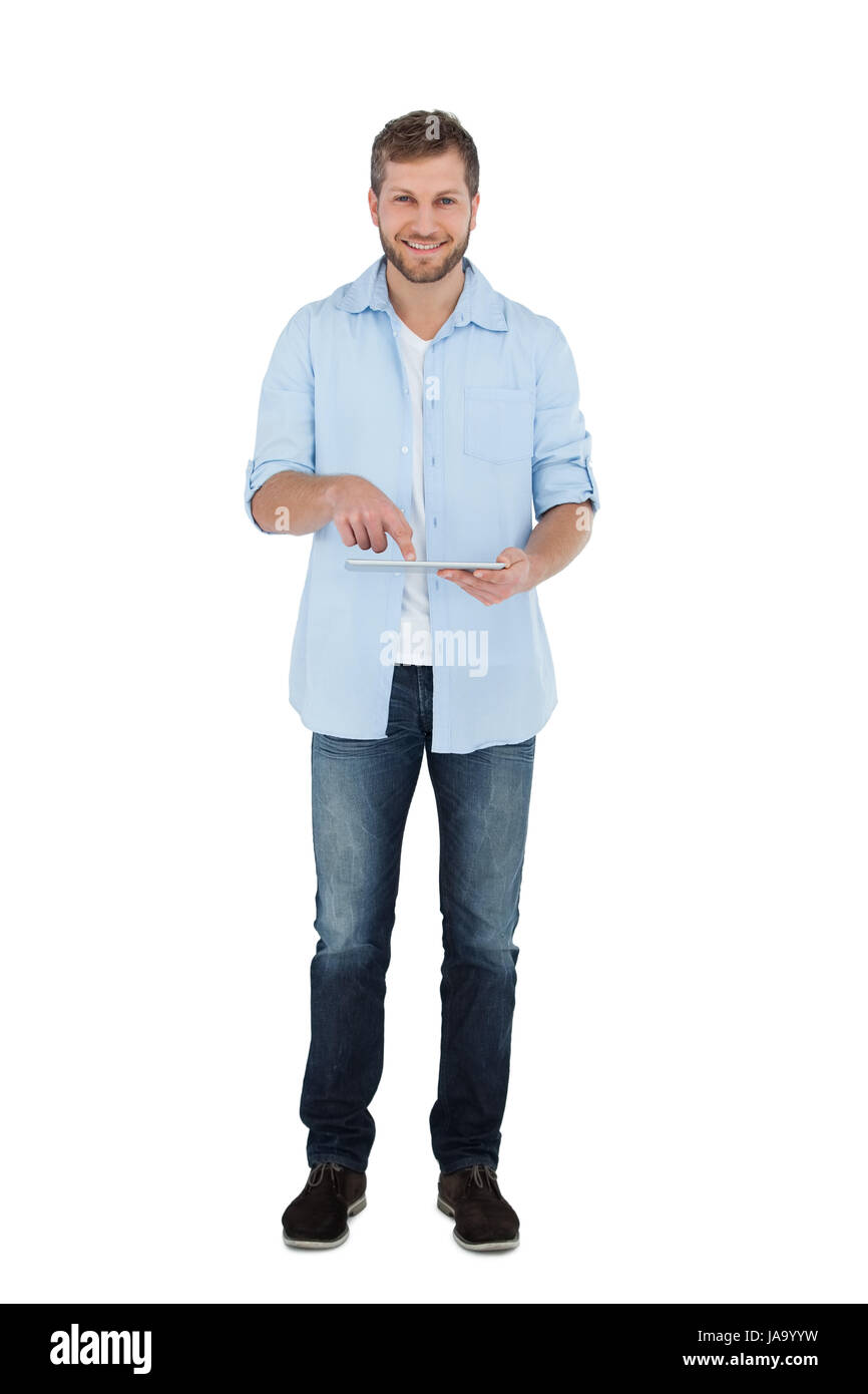 Relaxed male model posing with tablet computer on white background ...