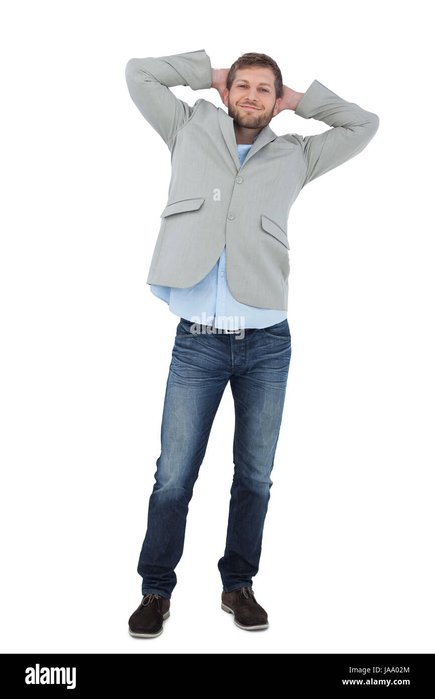 Suave man in a blazer with hands behind head looking at camera on white ...